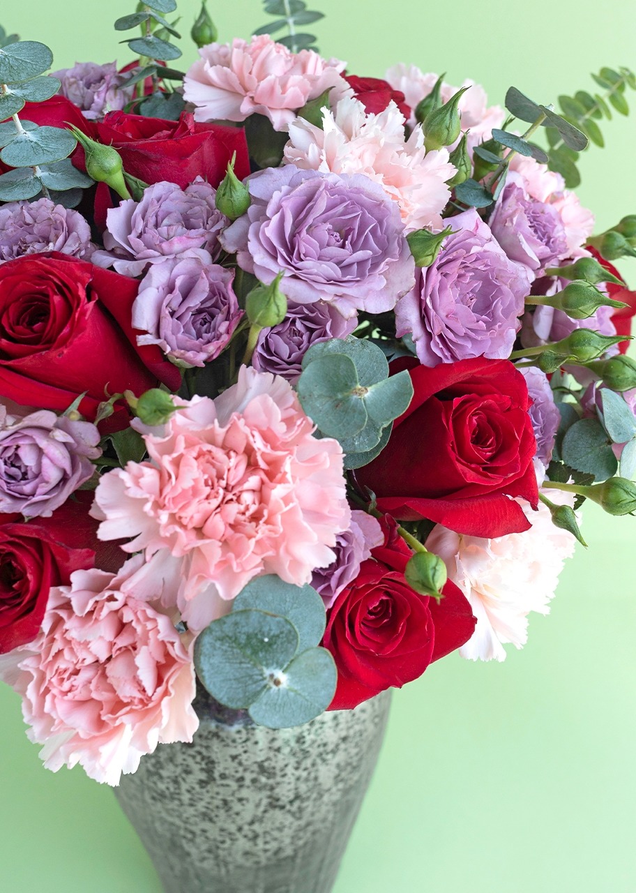 12 Rosas rojas y mini rosas en jarrón jaspeado platinado